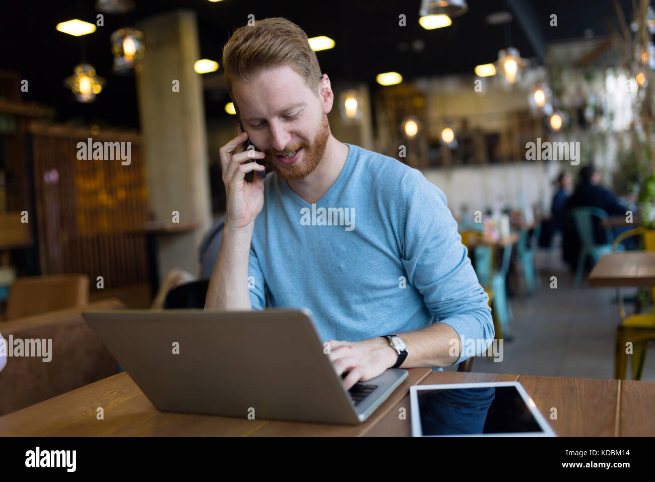 Young man having phone call in coffee shop Stock Photo - Alamy