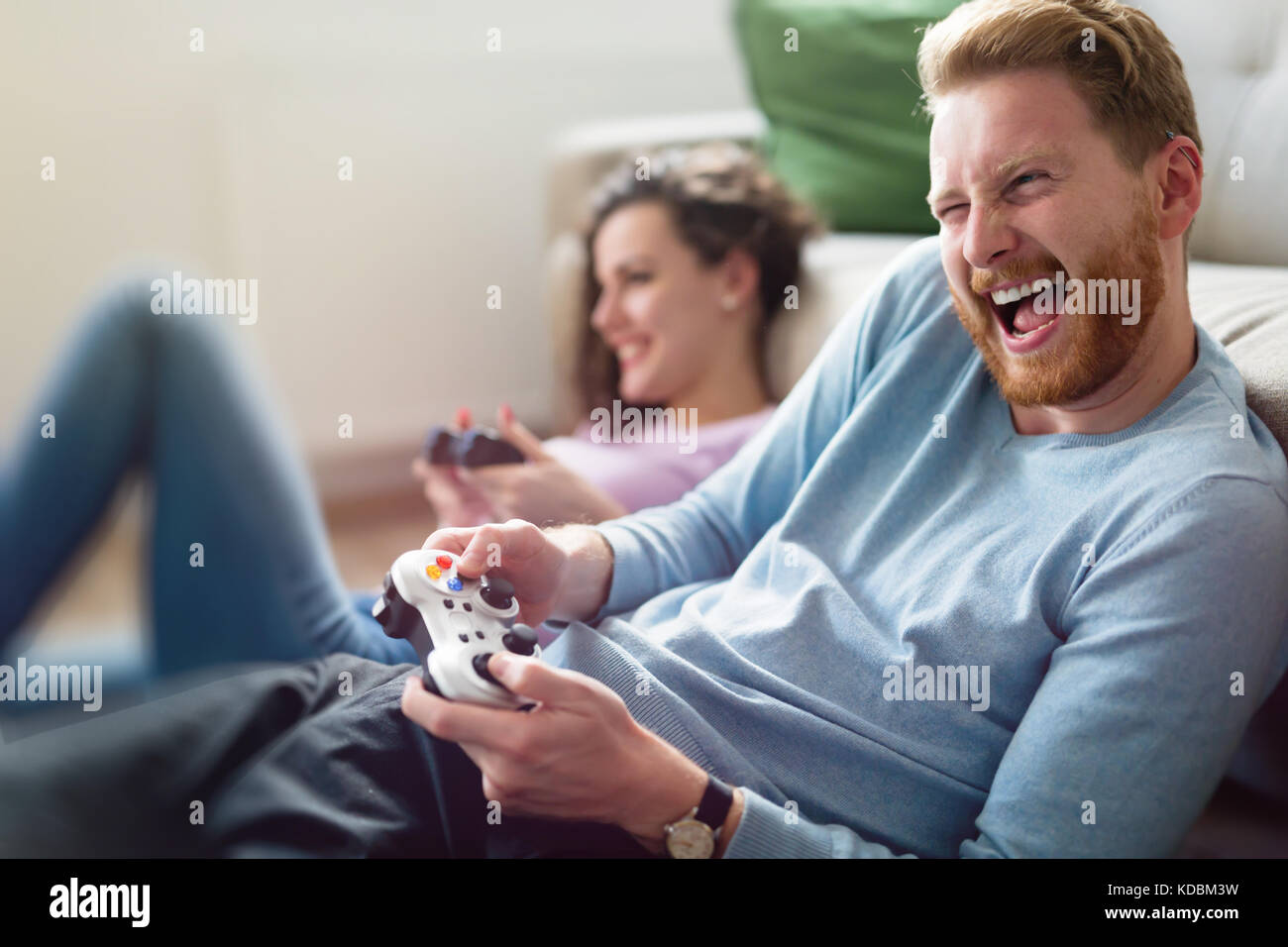 Happy couple playing video games at home Stock Photo - Alamy