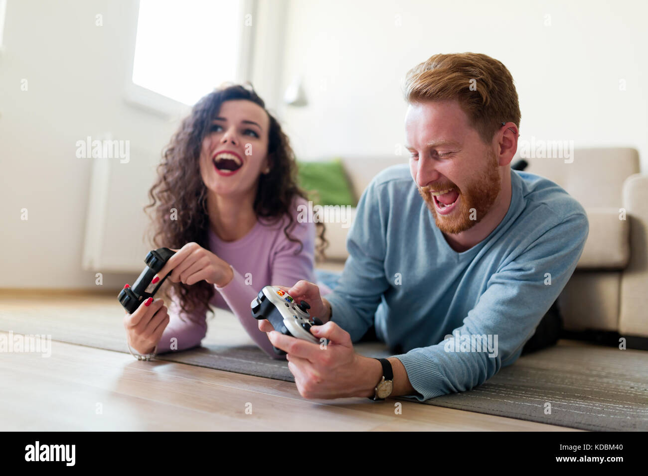 Happy couple playing video games at home Stock Photo - Alamy