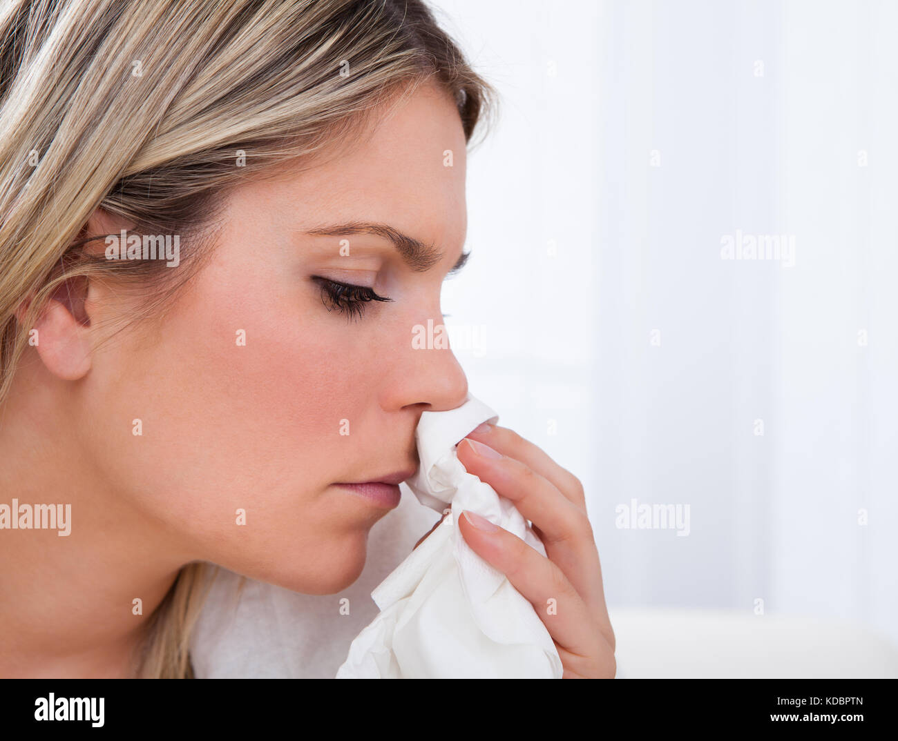Infected woman blowing his nose in tissue paper Stock Photo - Alamy