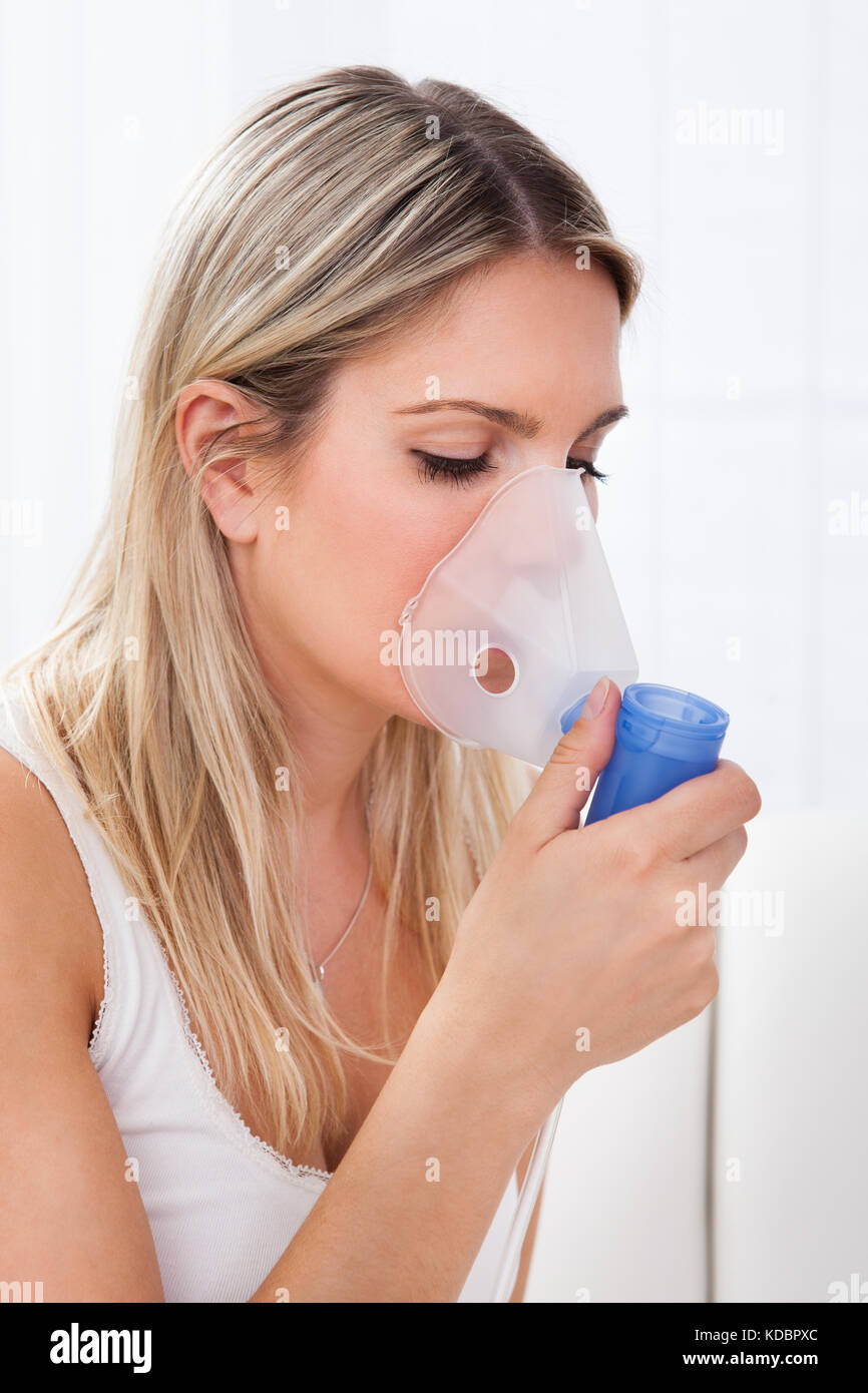 Woman with asthma using an asthma inhaler for preventing attacks Stock ...