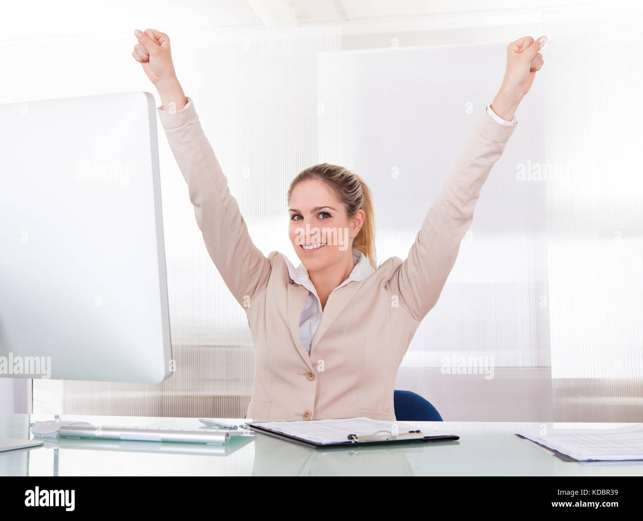 Happy Businesswoman Raising Her Hand In Office Stock Photo - Alamy