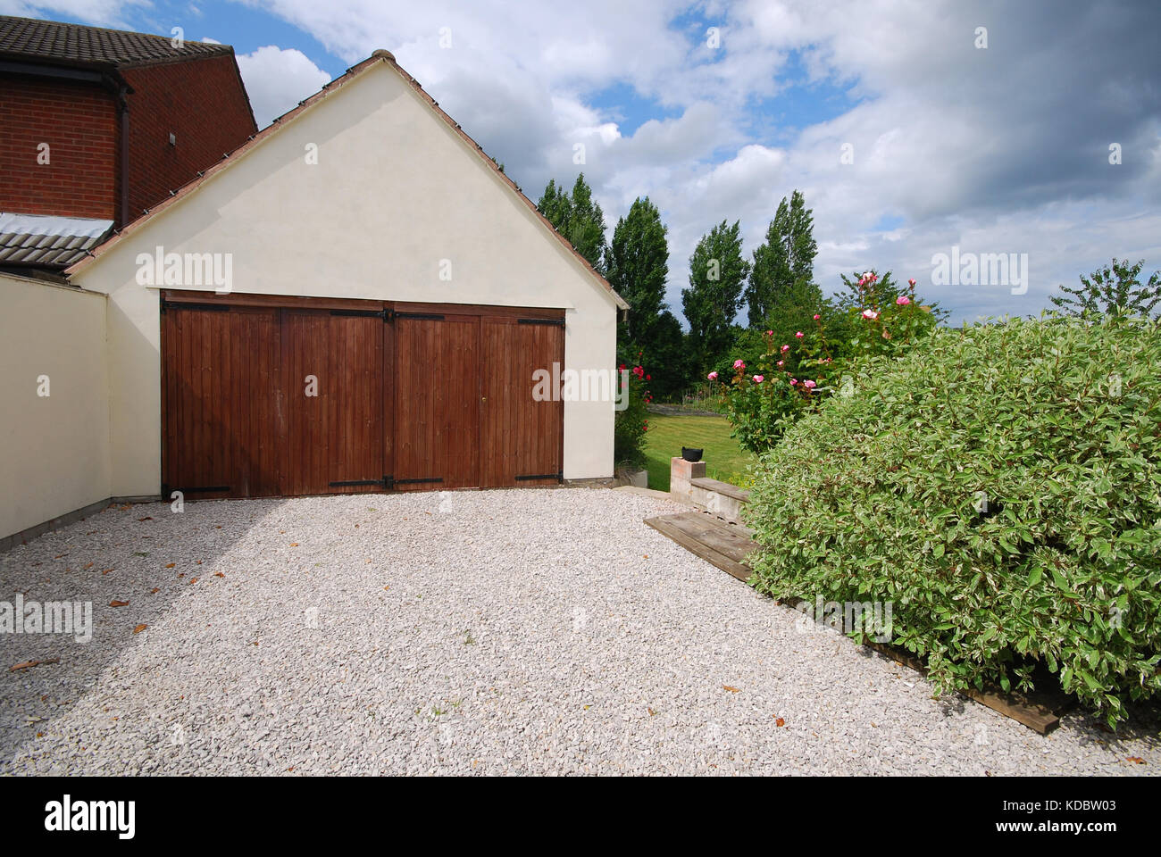 Large garage with white rendering and double wooden doors Stock Photo ...