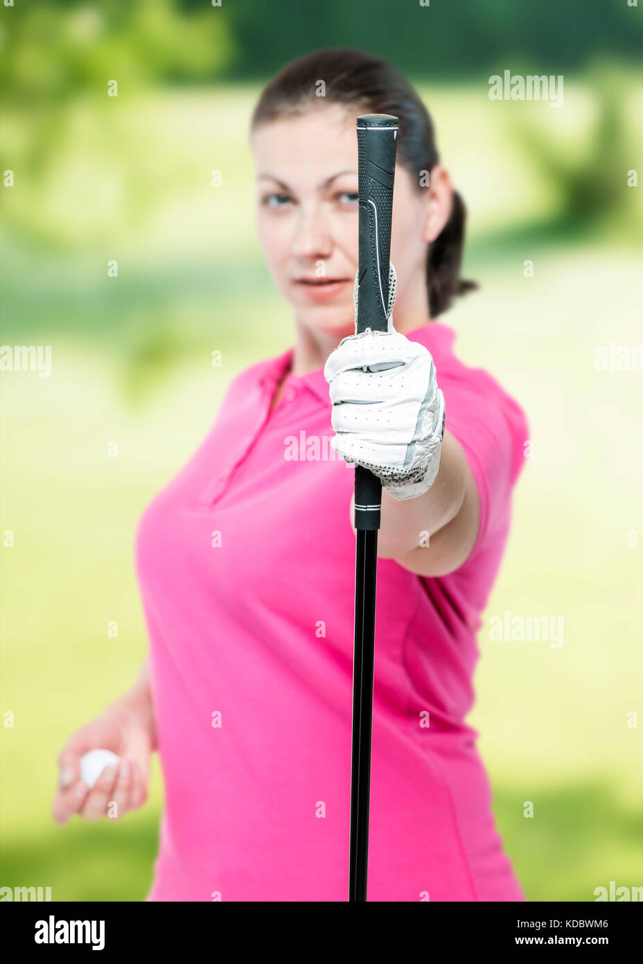 athlete shows a golf club at the camera on a background of golf courses ...