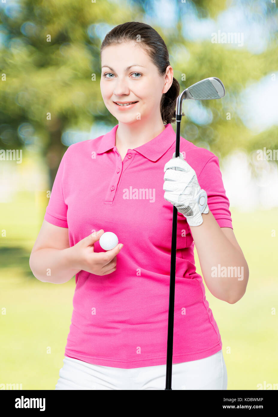 smiling girl posing with a golf club on a background of golf courses ...