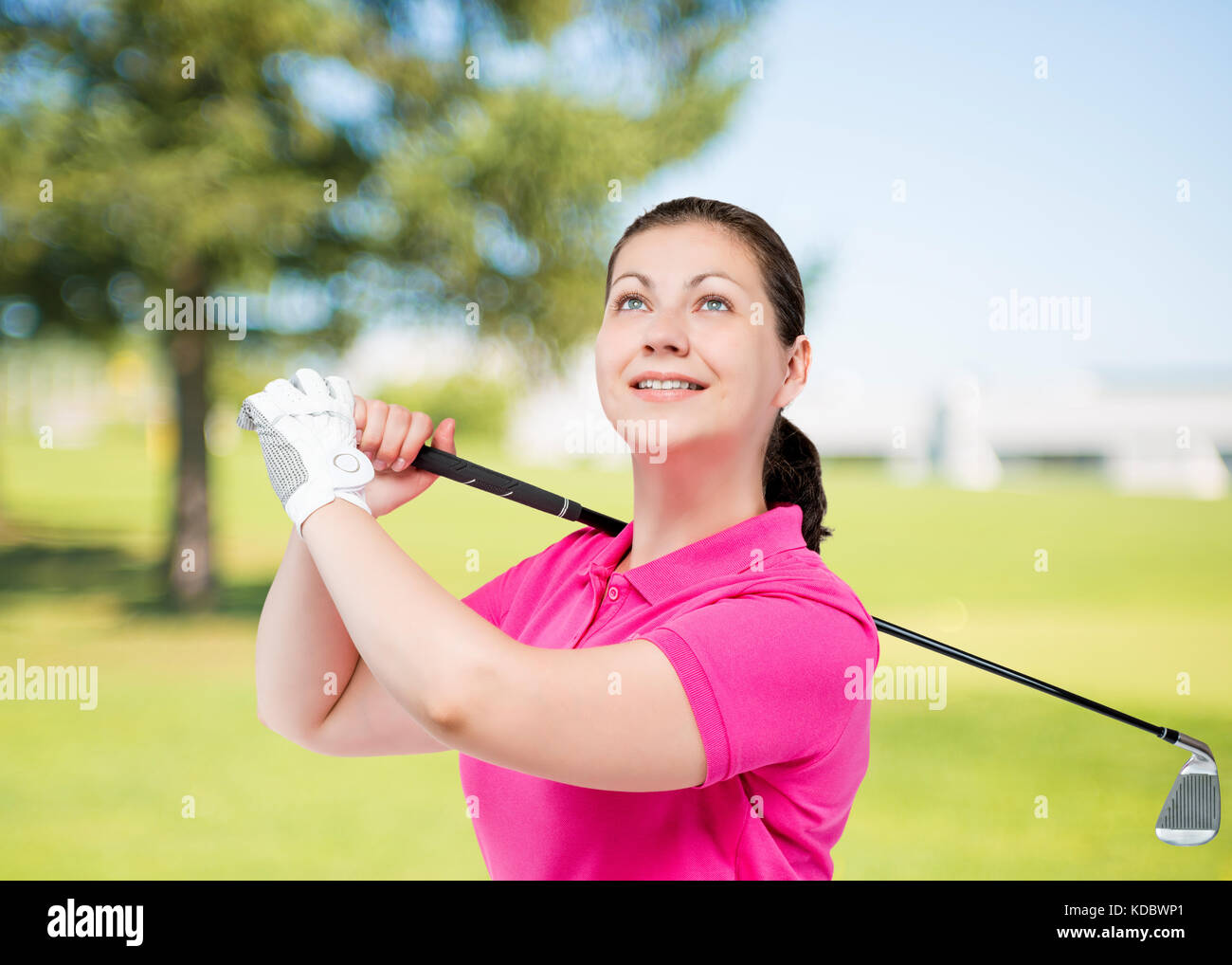 Portrait of a professional golfer in pink T-shirt with a golf club on a ...