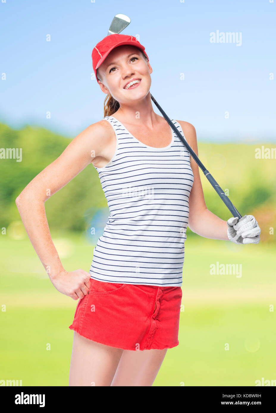 Cheerful girl with a golf club in a red cap and skirt on a background ...