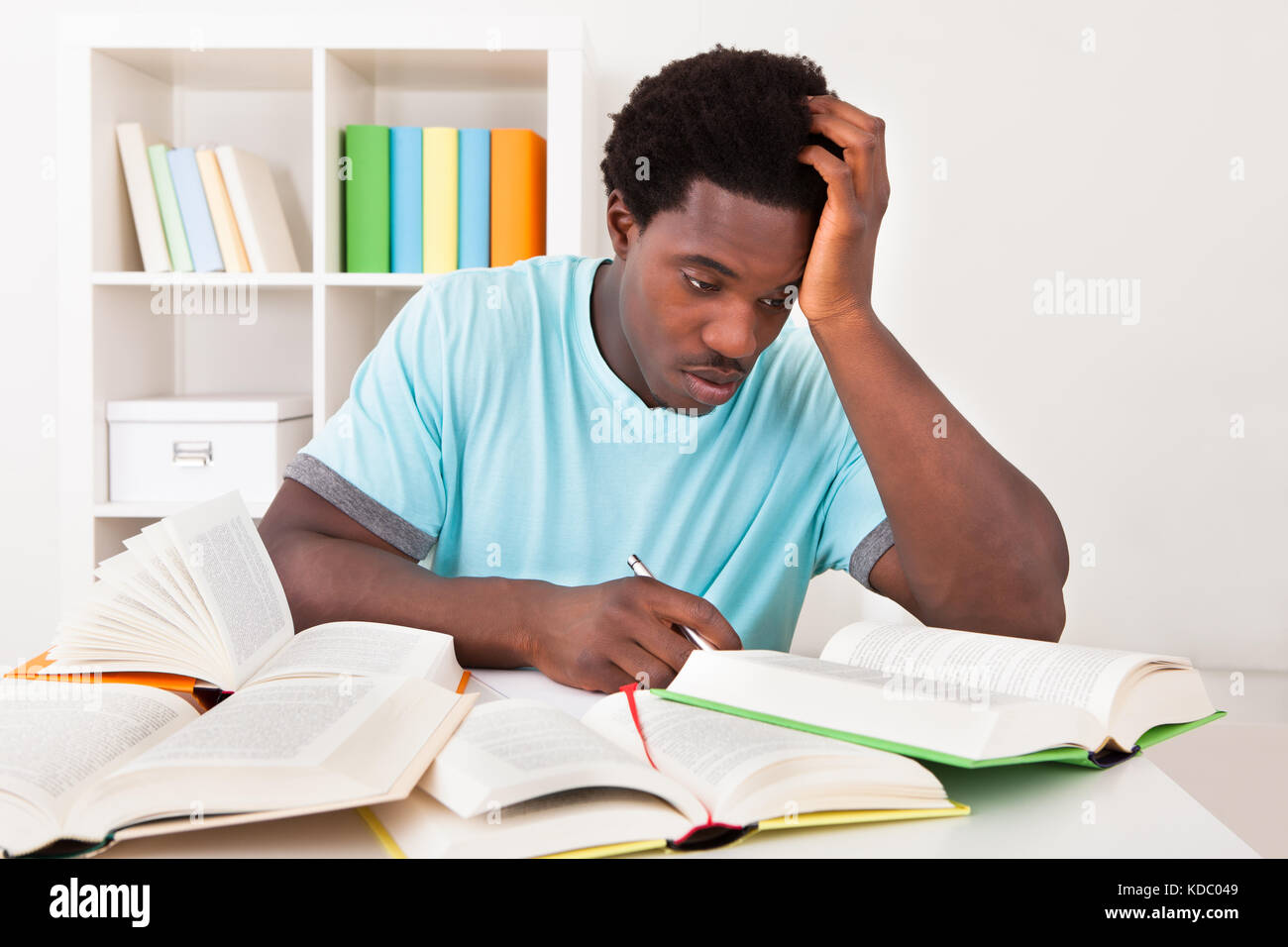Worried Young African Man Studying At Home With A Lot Of Books Stock ...