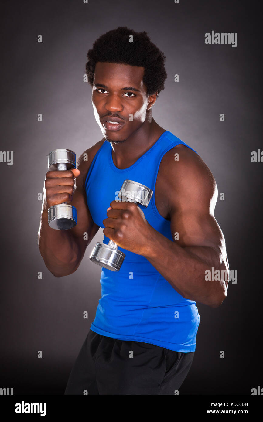Young African Man Working Out With Dumbbells Stock Photo - Alamy