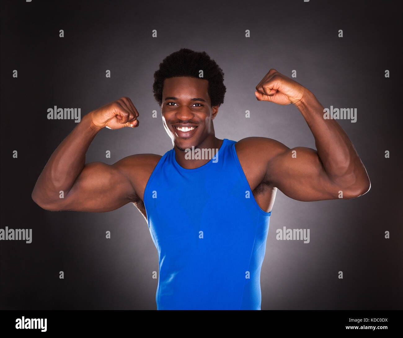 Happy Young African Man Showing Muscle Over Black Background Stock ...