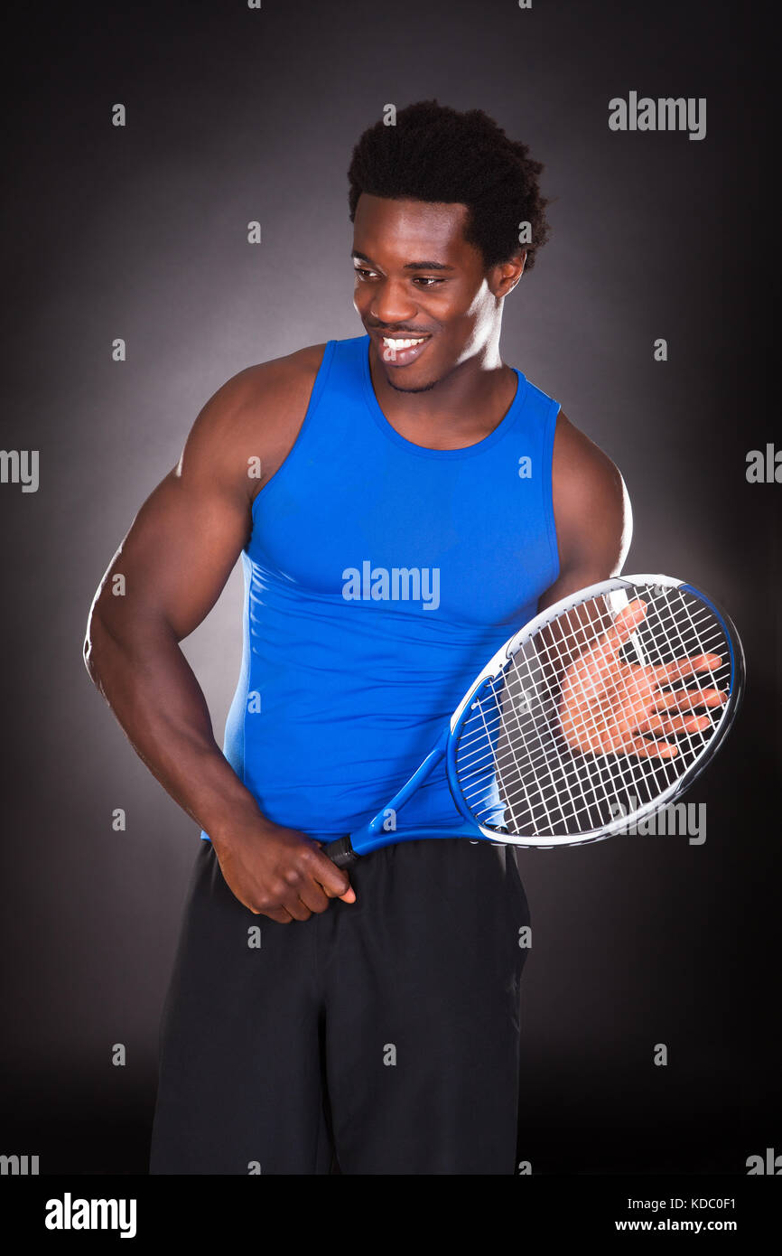 Happy Young African Man Holding Tennis Racket Over Black Background ...