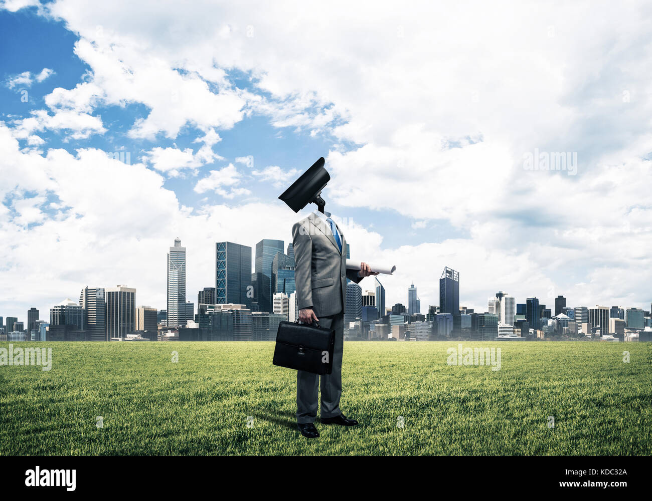 Camera headed man standing on green grass against modern citysca Stock ...