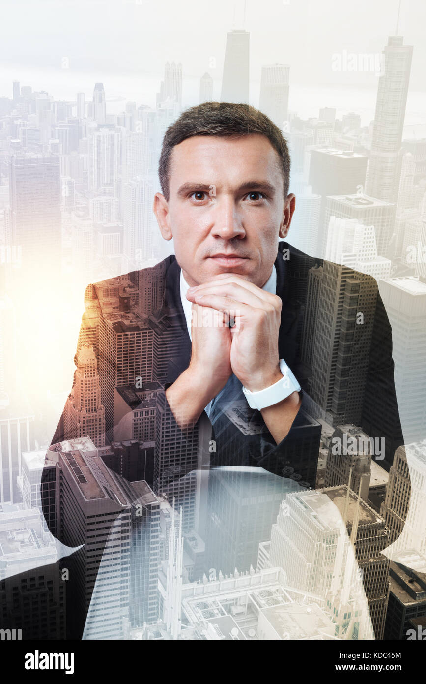 Emotional manager sitting on a chair and looking impressed Stock Photo ...