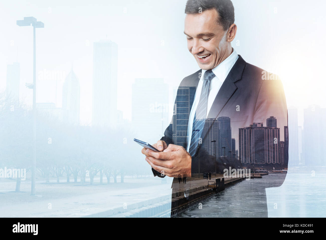 Delighted businessman getting a message on his smart phone Stock Photo ...