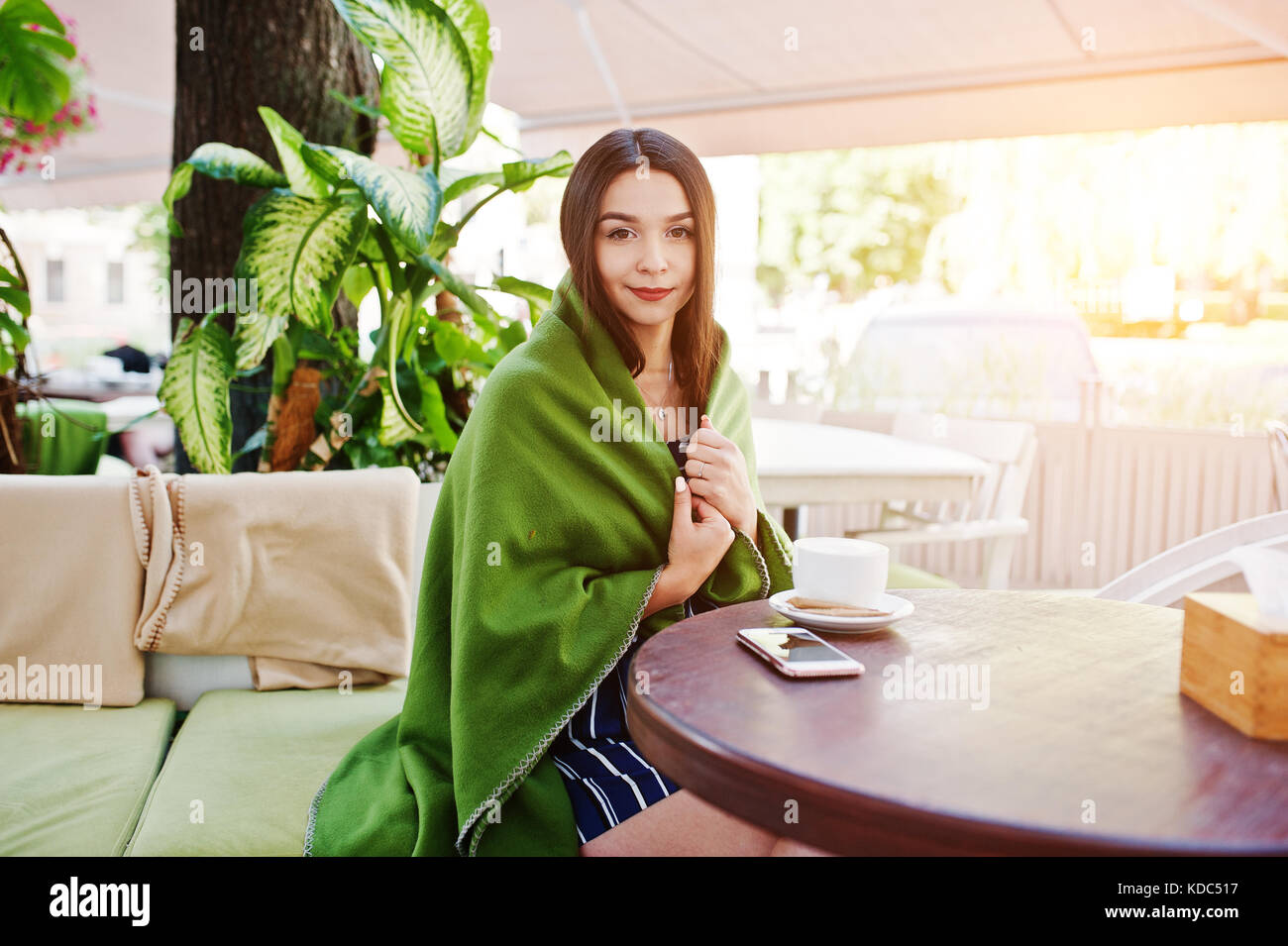 Gorgeous brunette girl sitting on the table in cafe cover plaid with ...