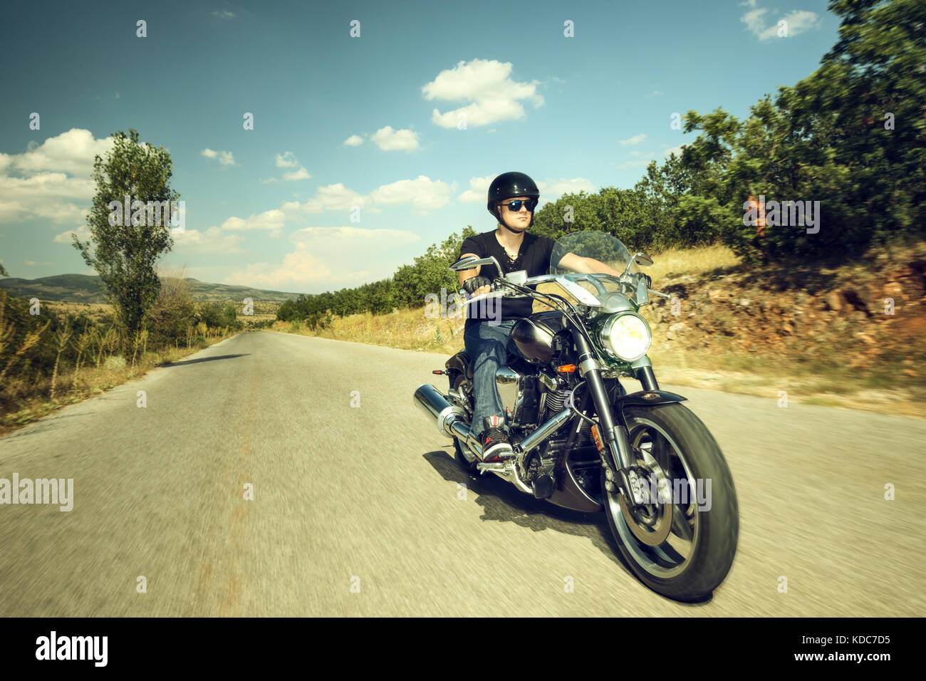 Biker riding a motorcycle on an open road Stock Photo - Alamy