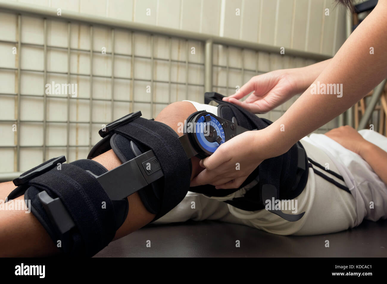 Female physiotherapy adjusting walking brace on patient's leg in clinic ...