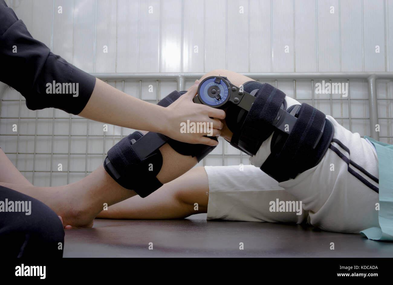 Female physiotherapy adjusting walking brace on patient's leg in clinic ...