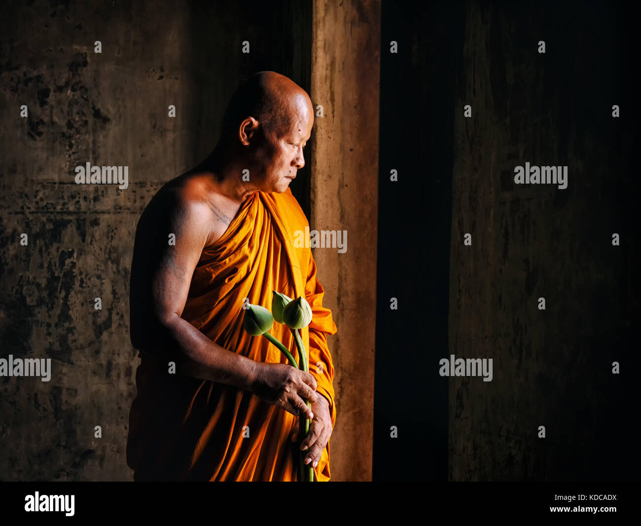 Buddhist monk hold lotus flower and standing in the temple Stock Photo ...