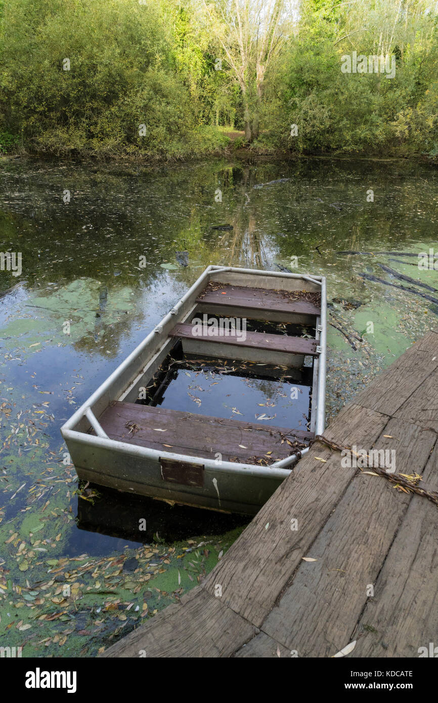 Water filled aluminium boat on lake Stock Photo - Alamy