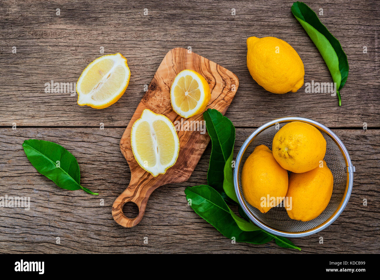 Fresh lemons and lemons leaves on rustic wooden background. Fresh ...