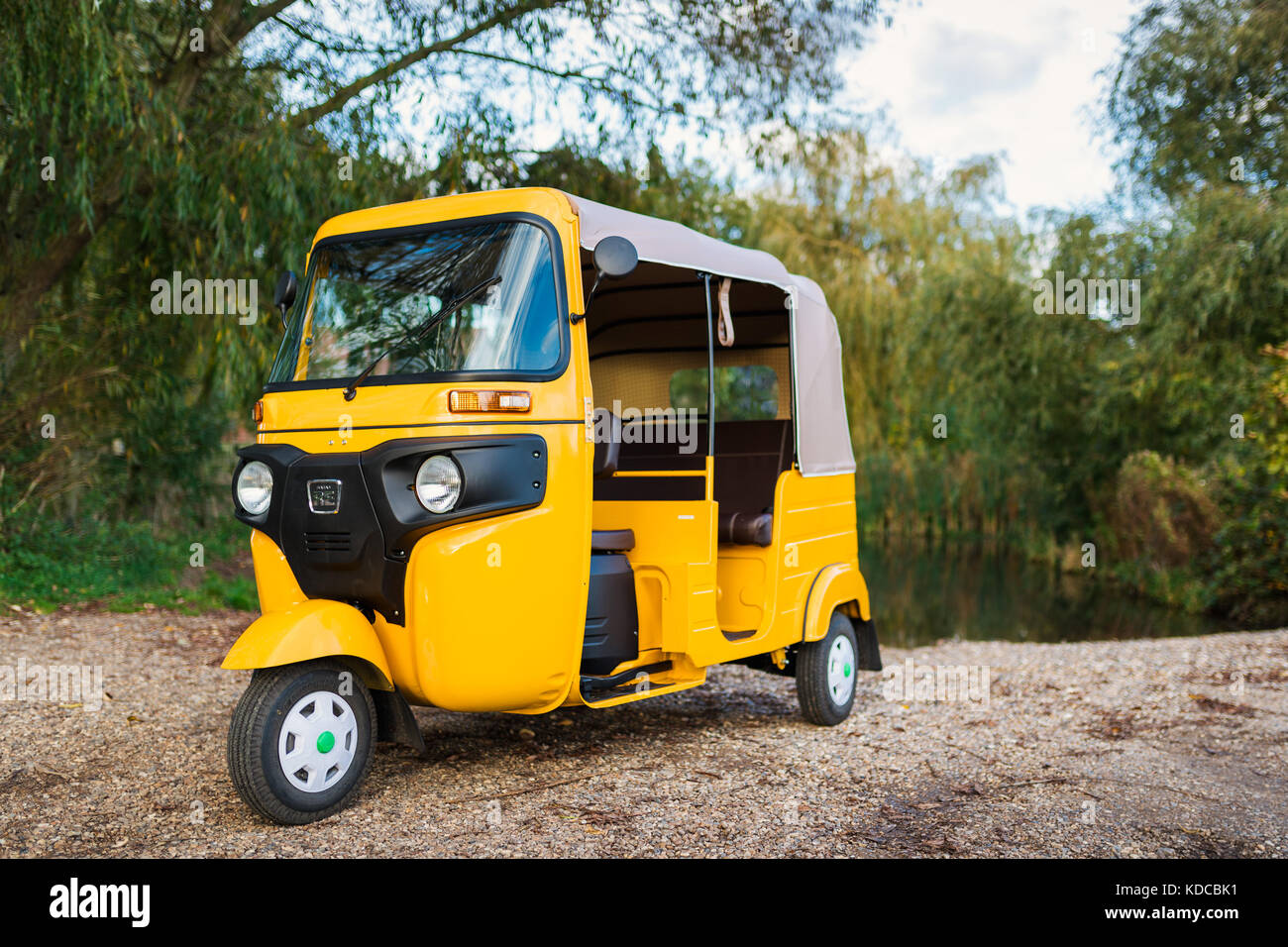 A yellow tuk tuk in an English village Stock Photo - Alamy