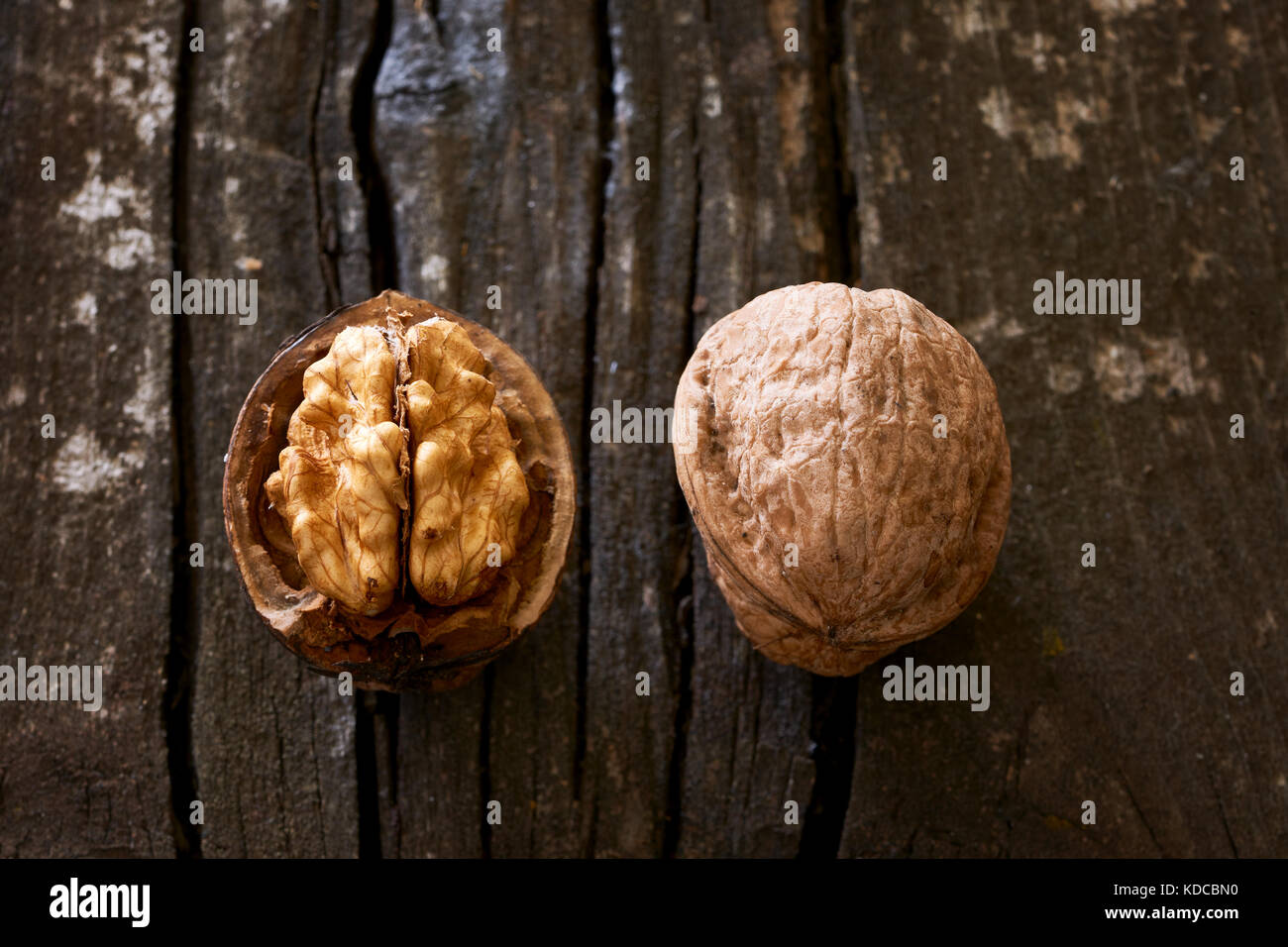 Two nuts, one open and one closed on an old wooden table Stock Photo ...