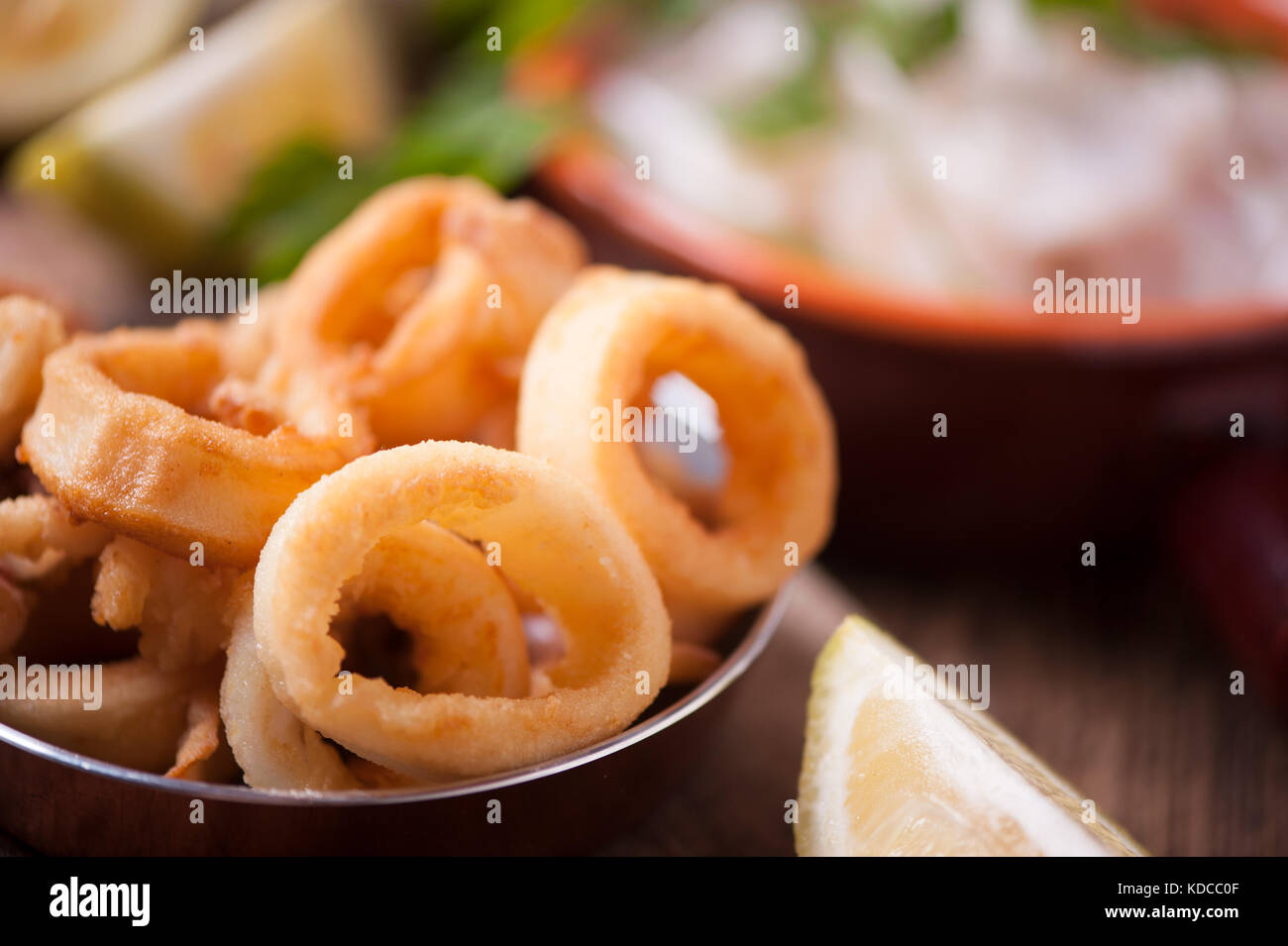 Fried calamari squid on wooden table Stock Photo - Alamy
