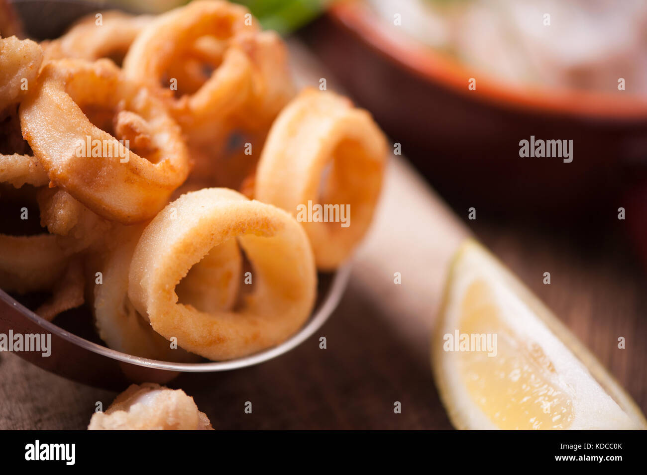 Fried calamari squid on wooden table Stock Photo - Alamy
