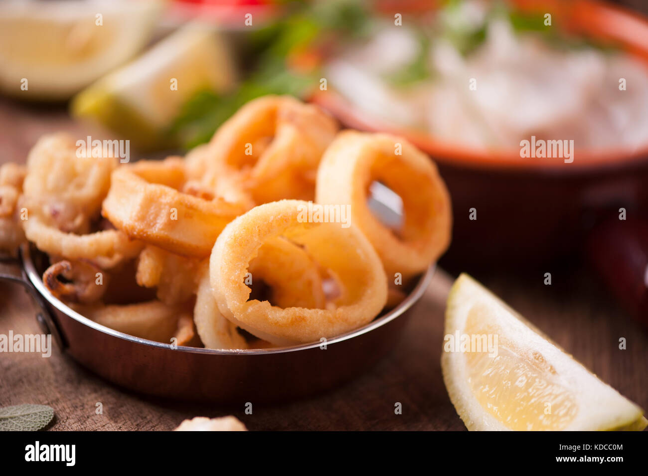Fried calamari squid on wooden table Stock Photo - Alamy