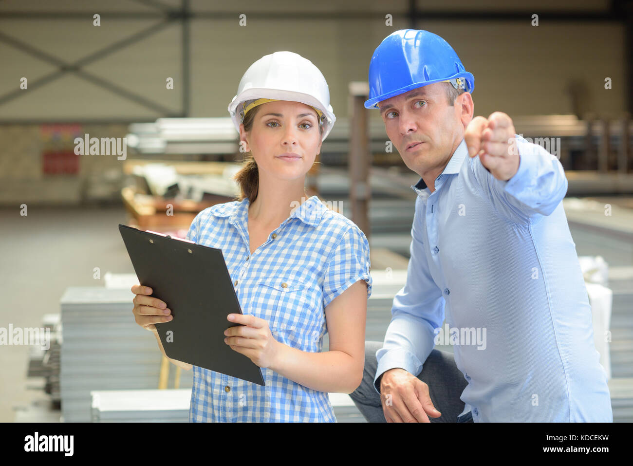 Man directing lady in builders yard Stock Photo - Alamy