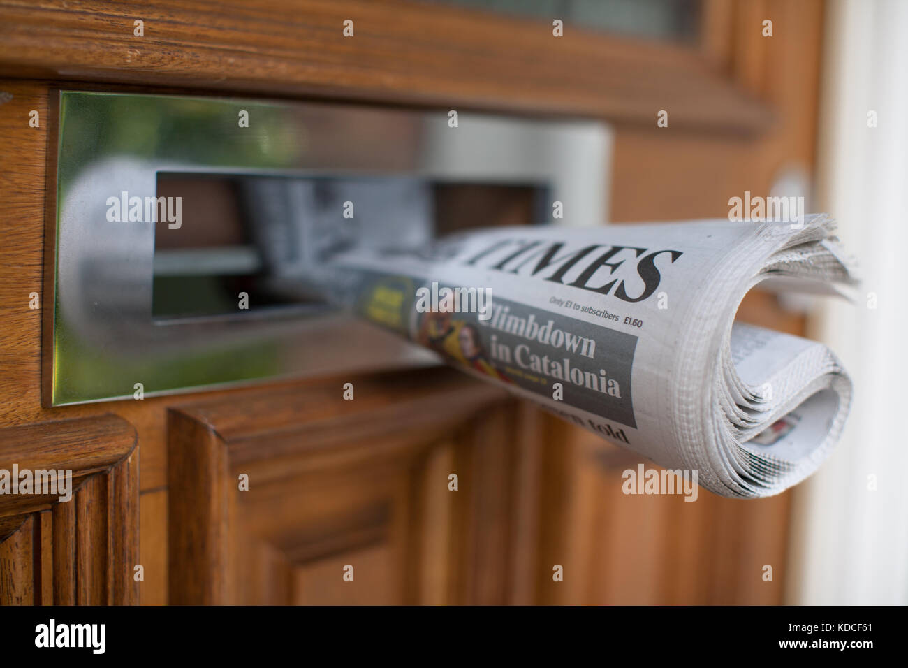 The Times daily newspaper being posted through letterbox of front door ...