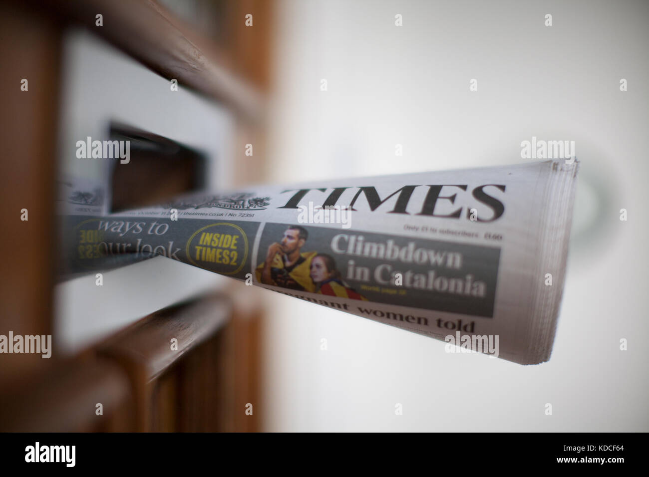 The Times daily newspaper being posted through letterbox of front door ...