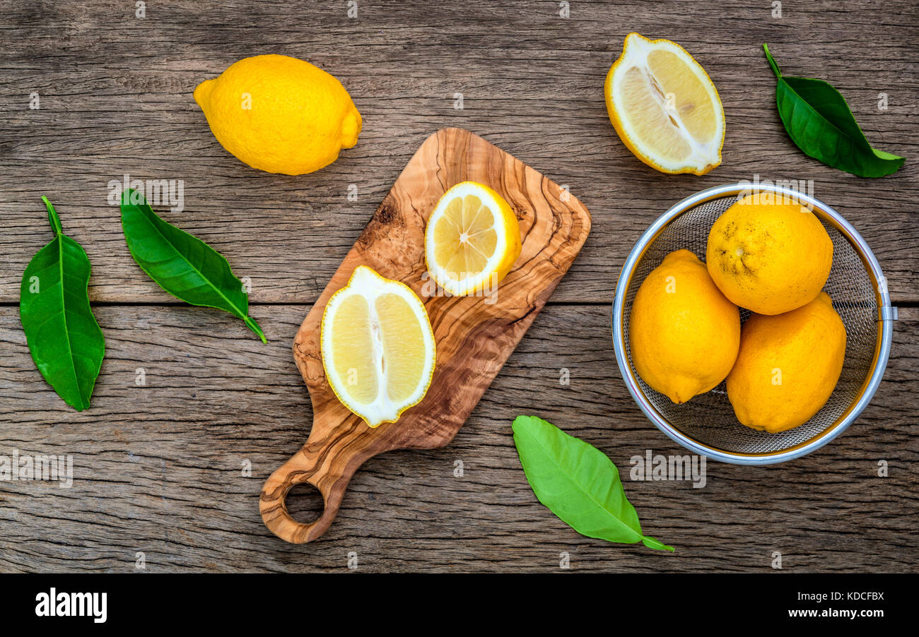 Fresh lemons and lemons leaves on rustic wooden background. Fresh ...