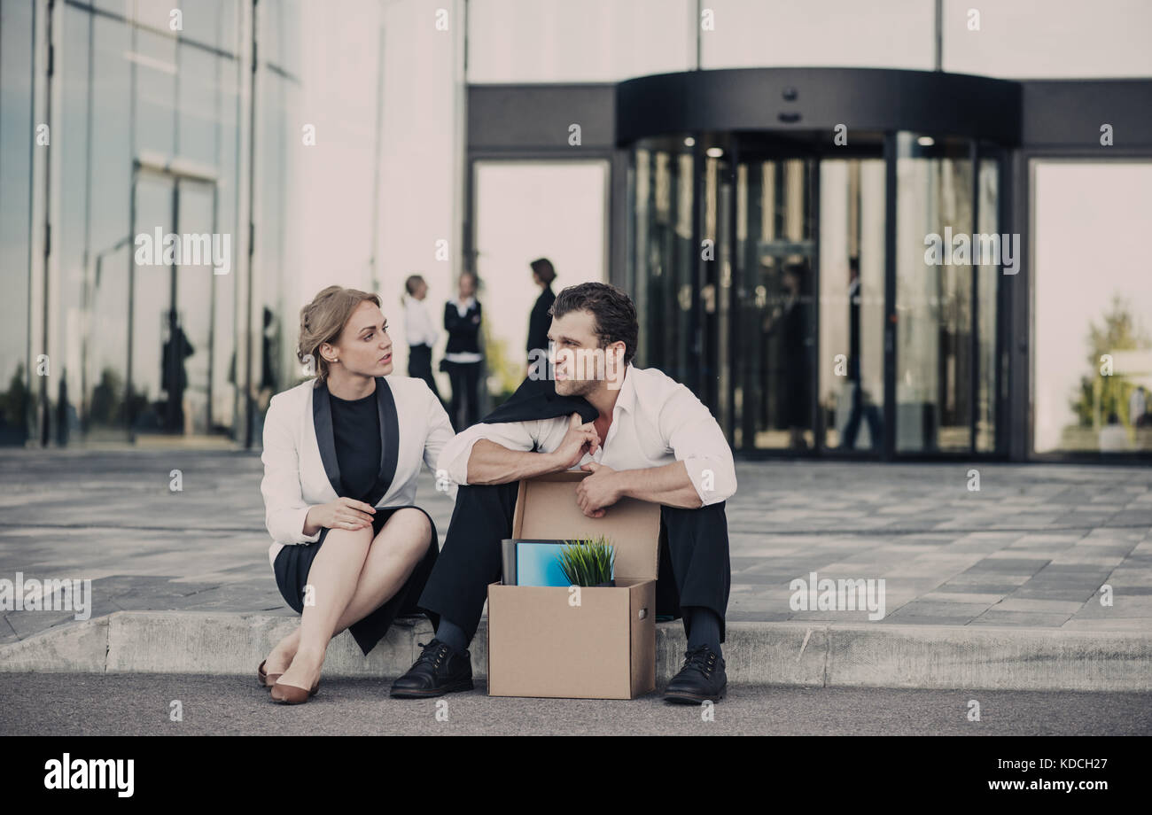 Fired business man sitting frustrated and upset on the street near ...