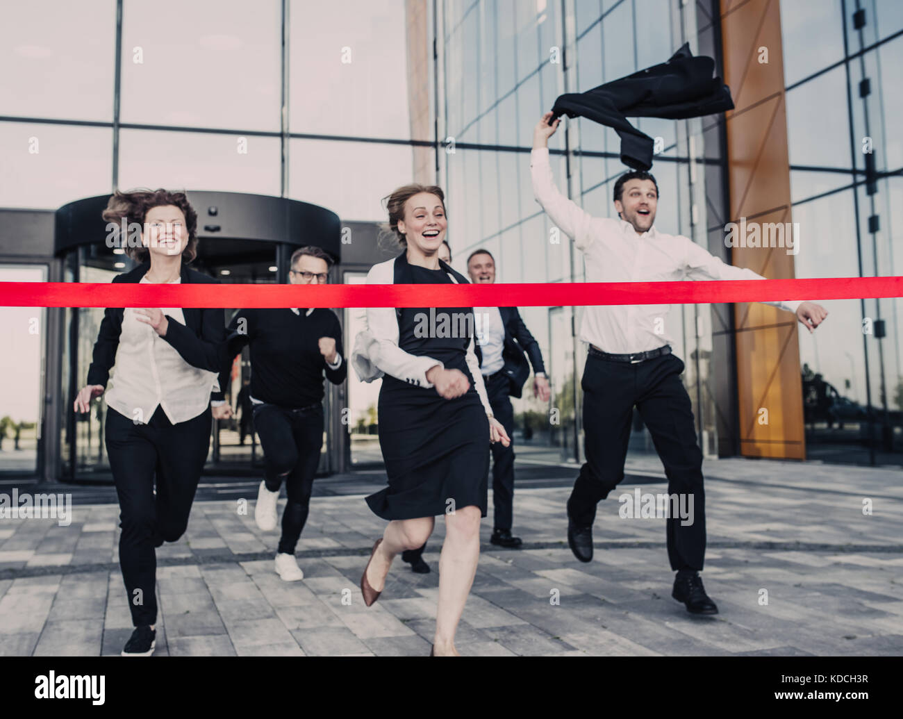 Group of happy business people running from office building crossing ...