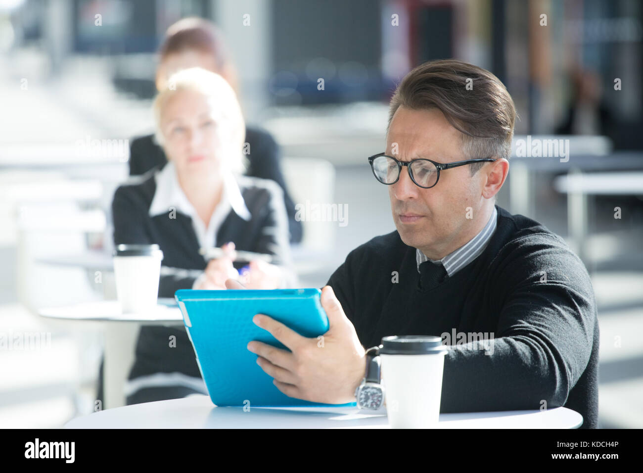 Lot of business people sitting in cafe of modern office building Stock ...