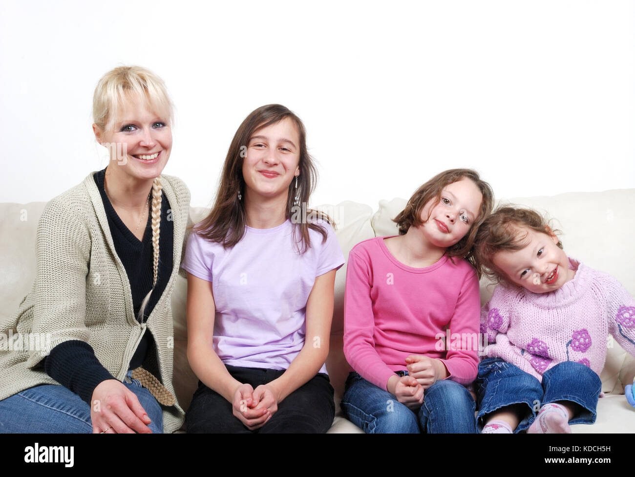 Family sitting in living room on sofa Stock Photo - Alamy