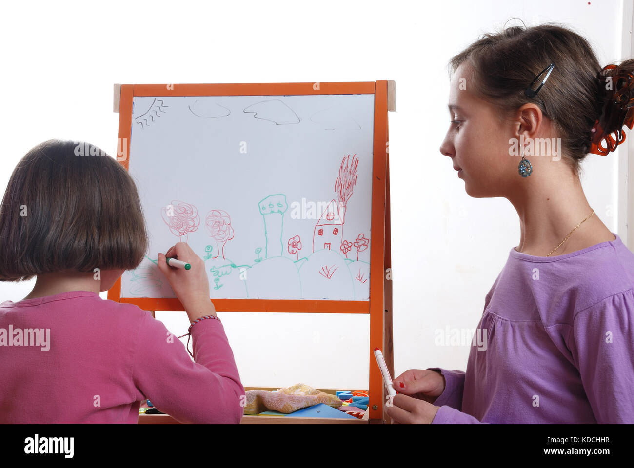 Youngs girls drawing on the white board Stock Photo - Alamy