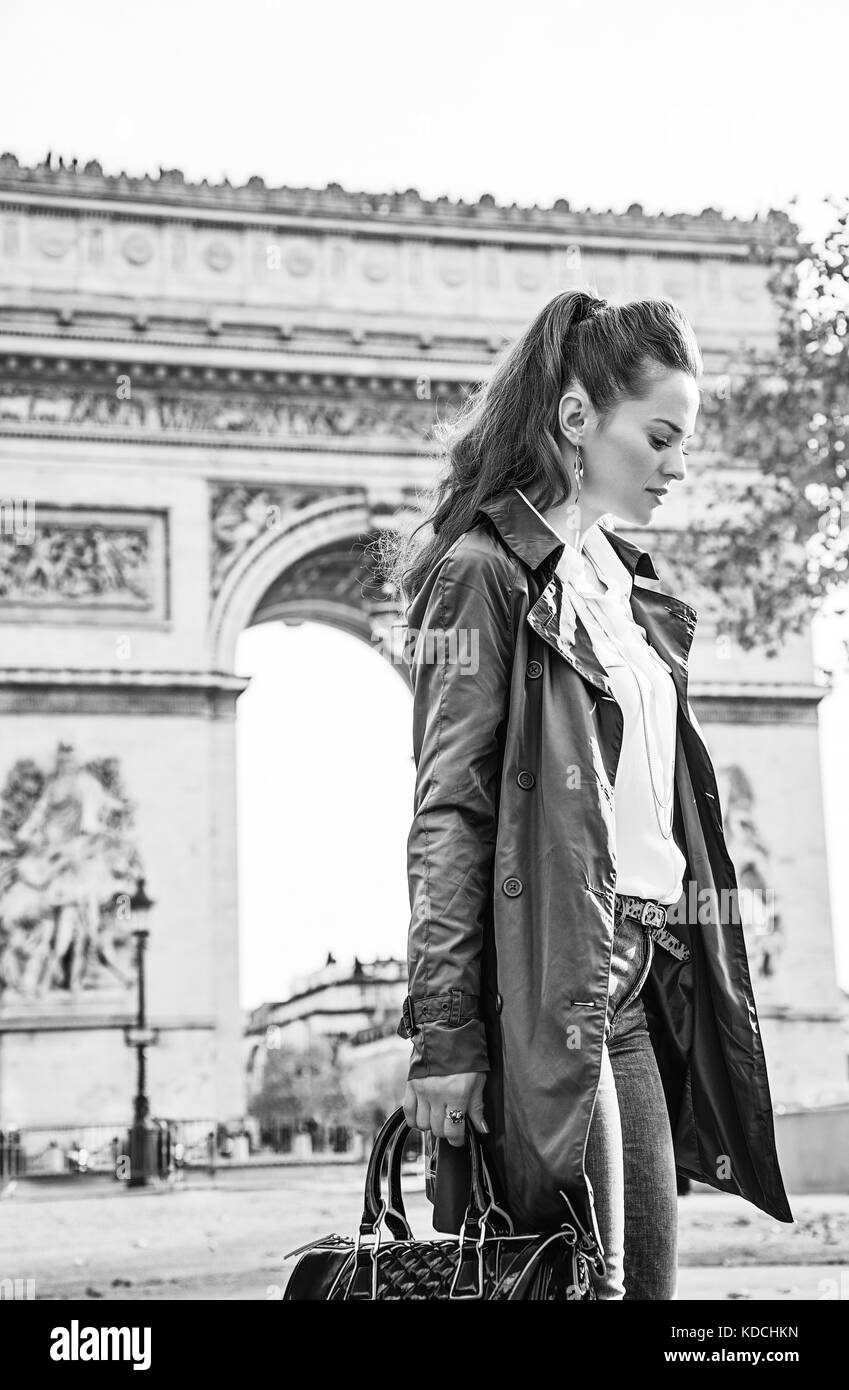 Stylish autumn in Paris. pensive modern woman in trench coat near Arc ...