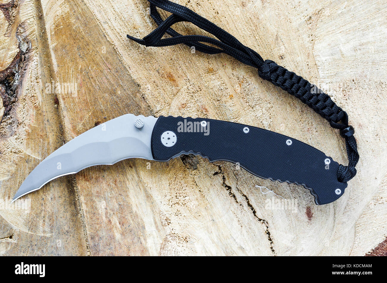 Knife blade in the shape of an eagle's beak. Natural background of wood ...