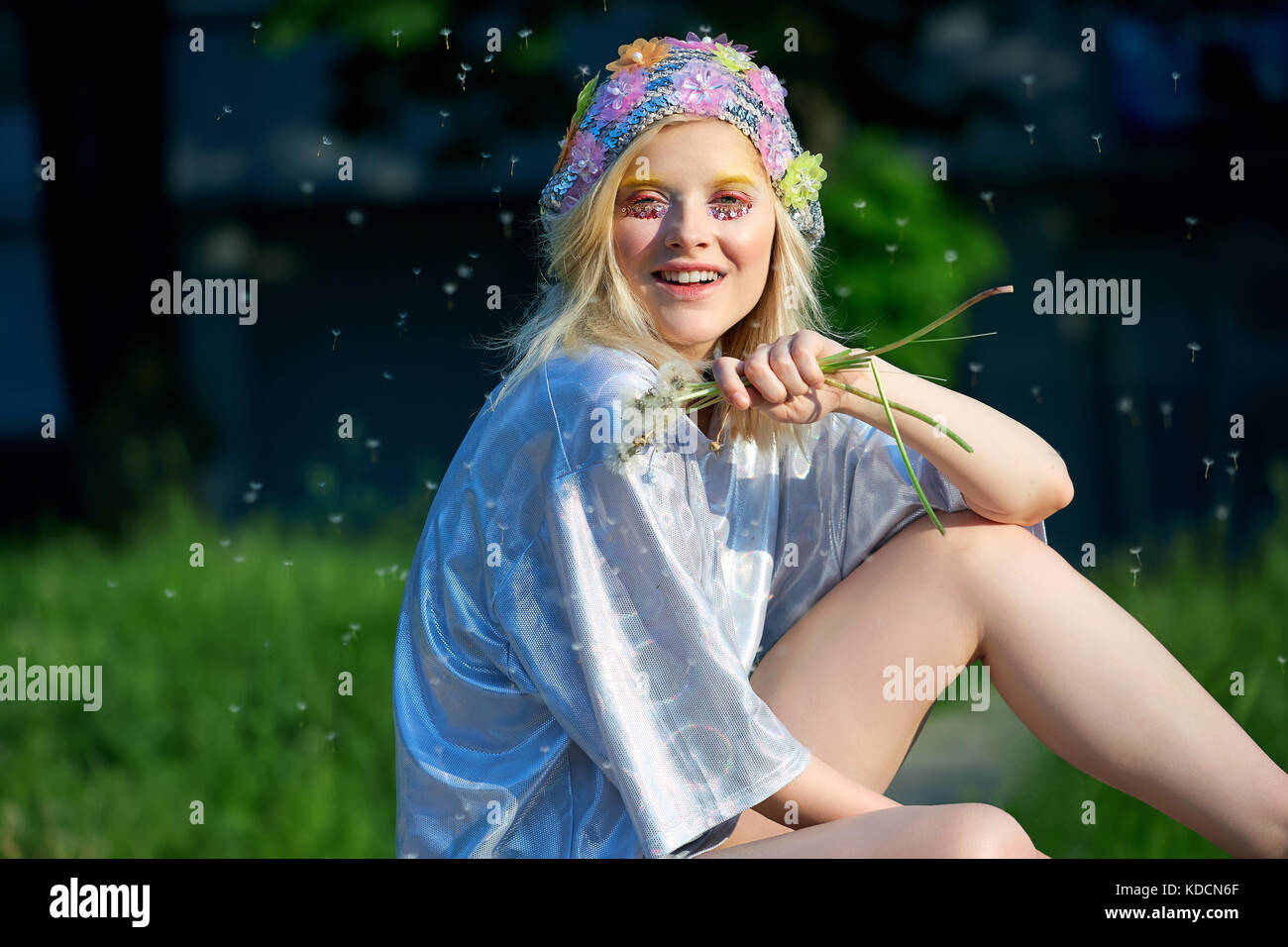 Young blond girl in sparkling hat with dandelions Stock Photo - Alamy
