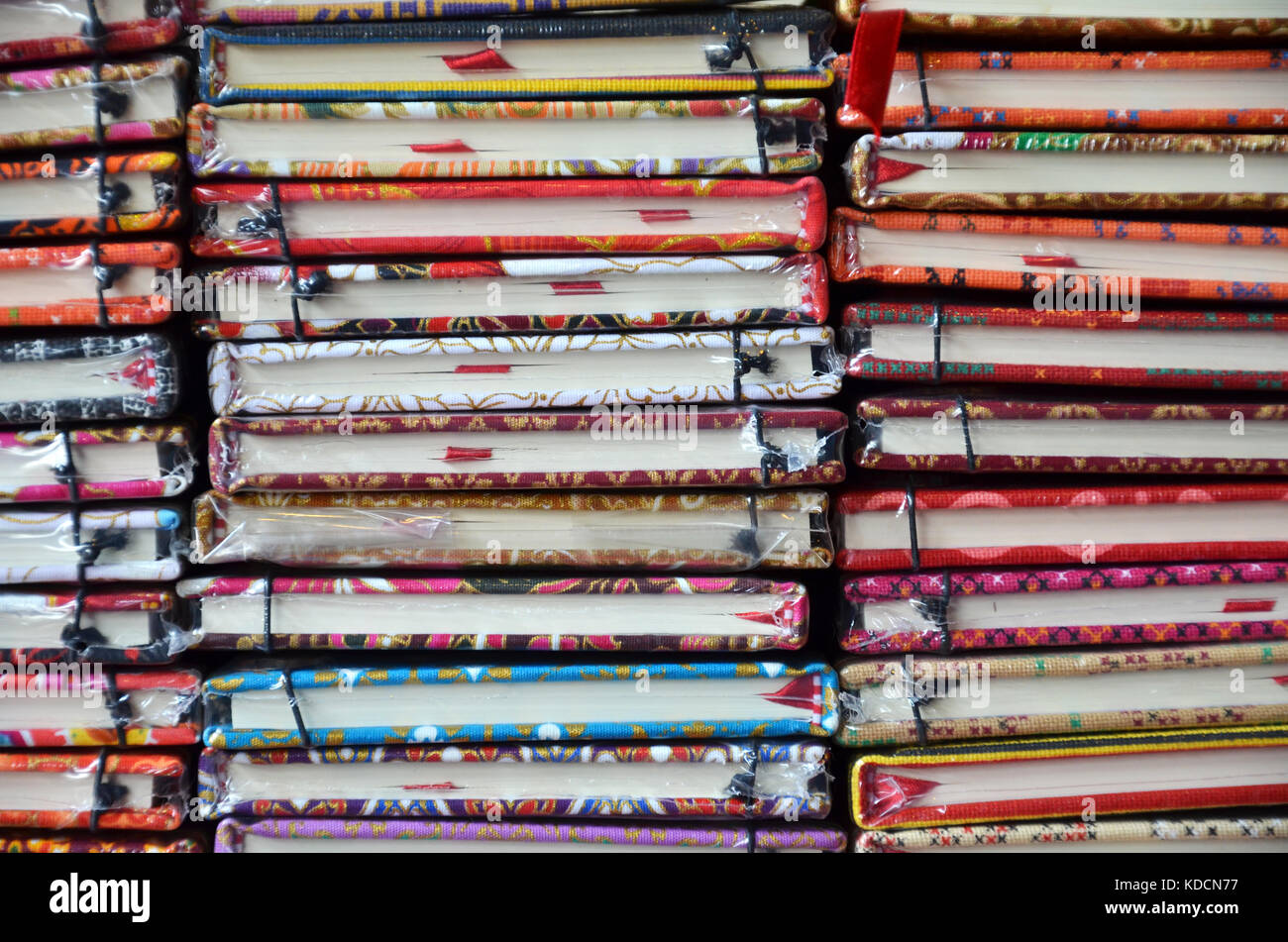 Stack of colorful notebooks on market for sale Stock Photo - Alamy