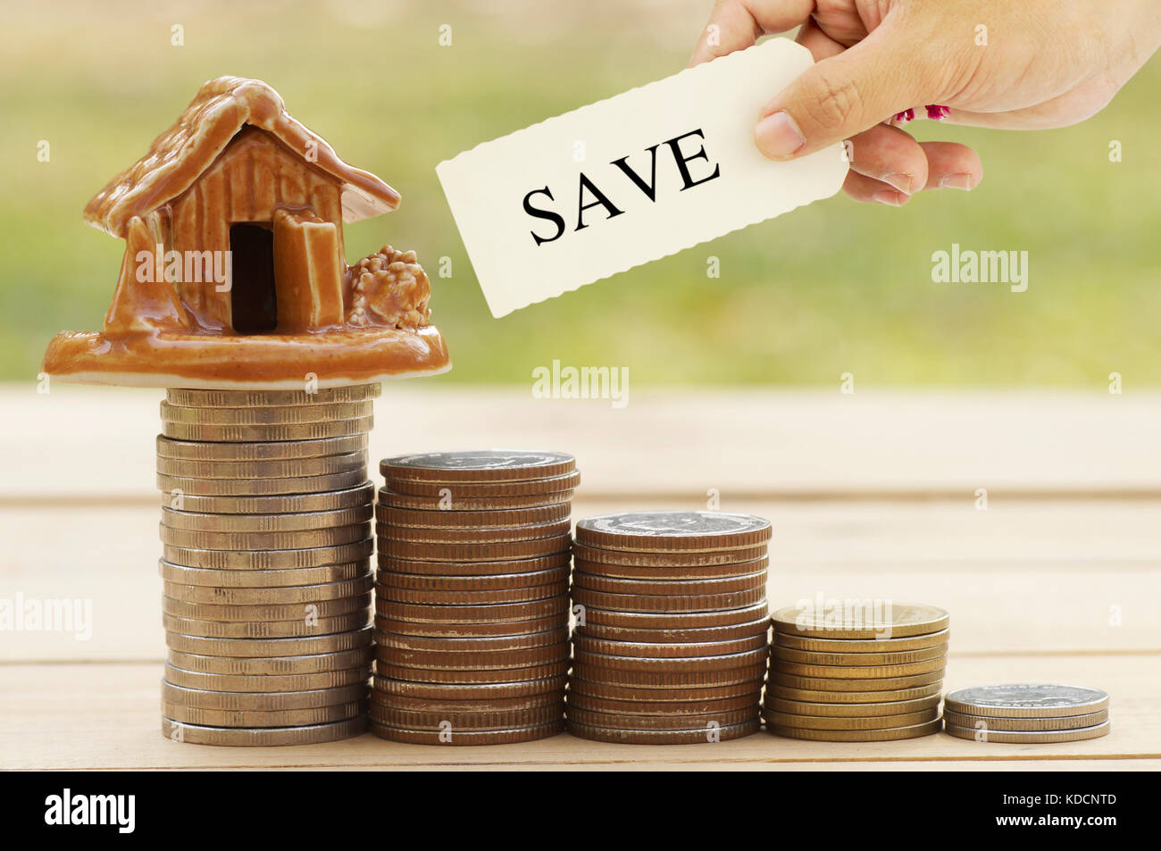 hand holding sign of save on coins and house on table, concept in save ...