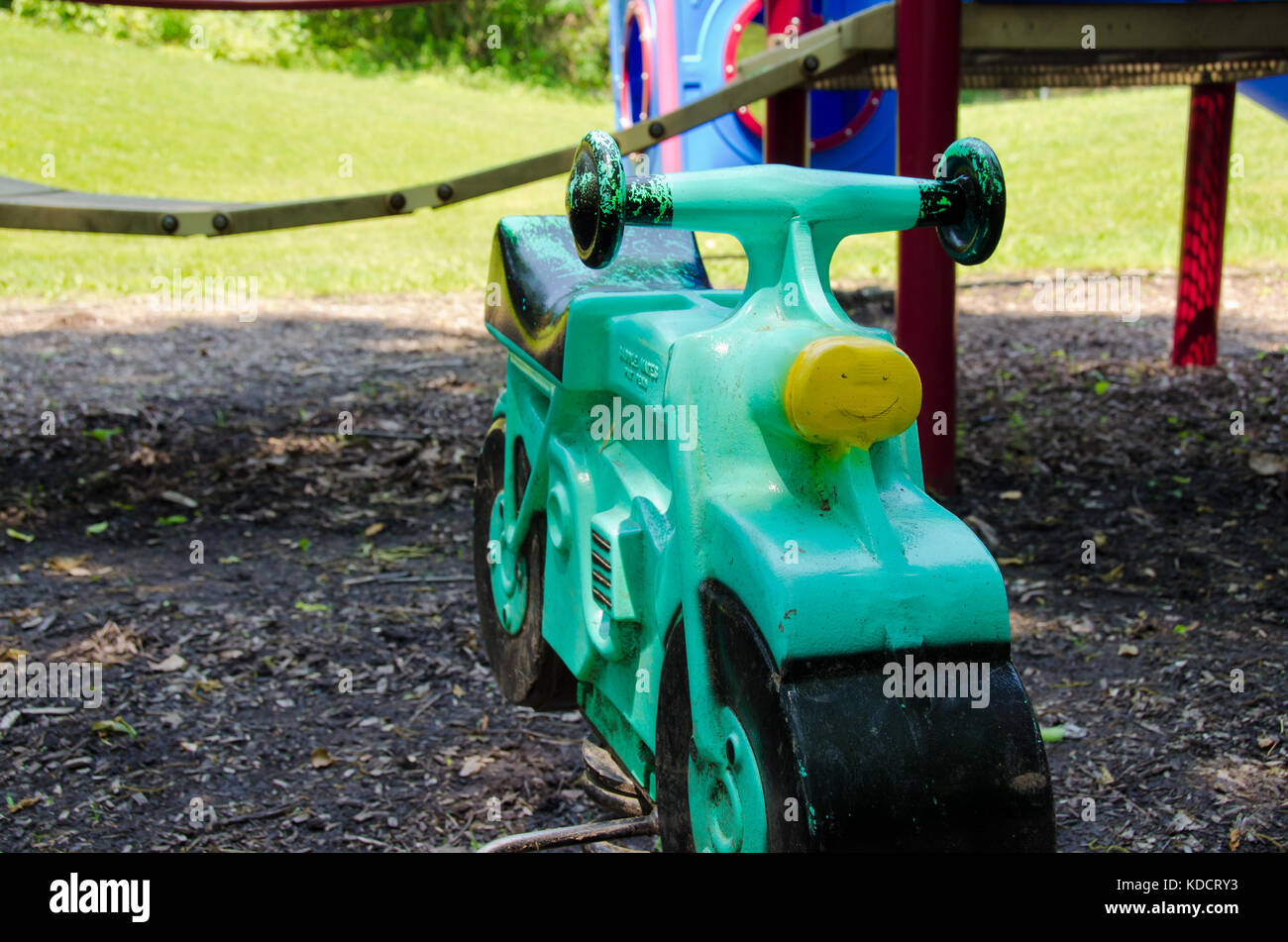Green motorcycle toy on a playground Stock Photo - Alamy