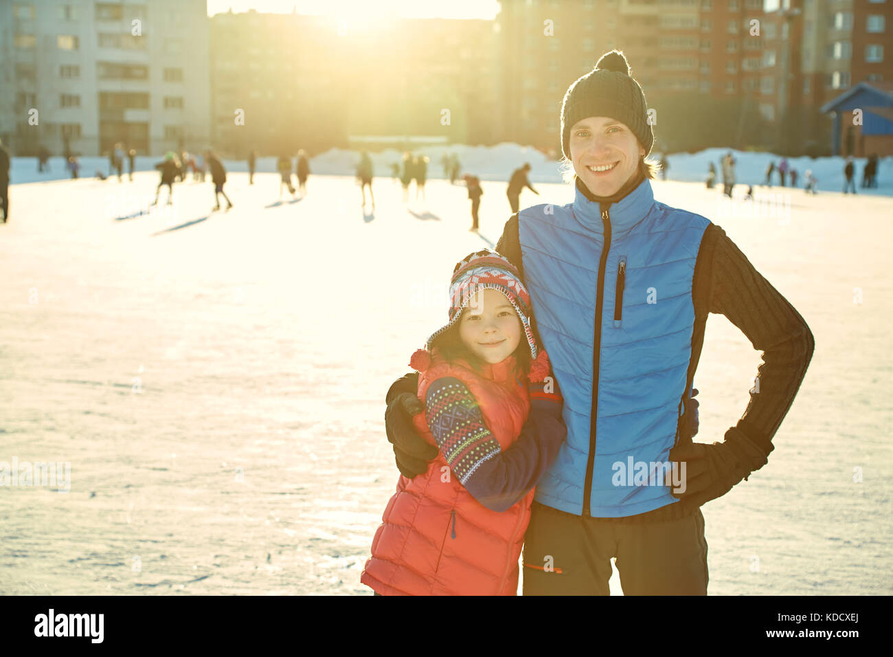 cute little girl with father ice skating. child winter outdoors on ice ...