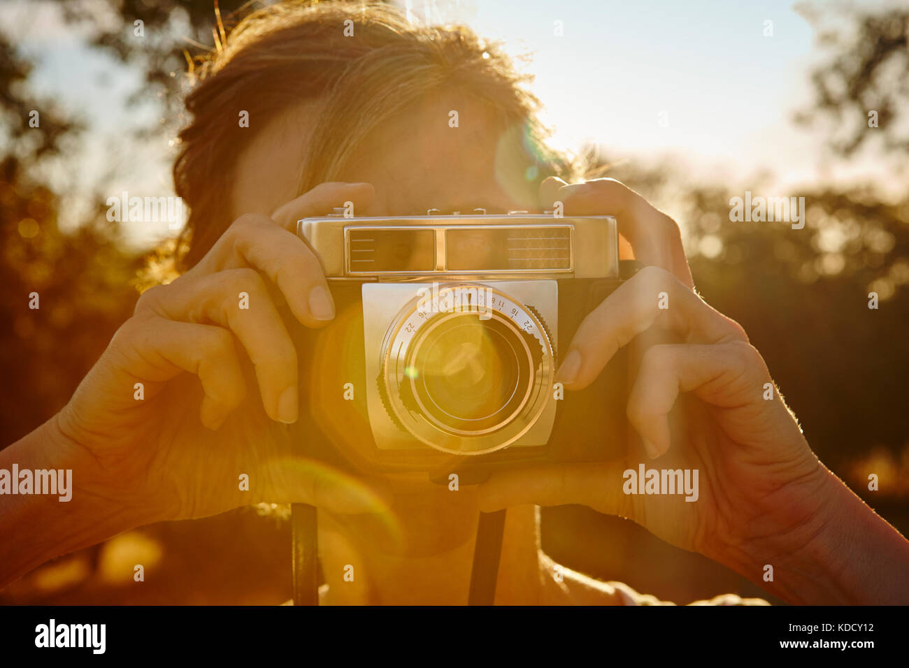 Woman taking pictures with vintage camera. Backlight. Travel background ...
