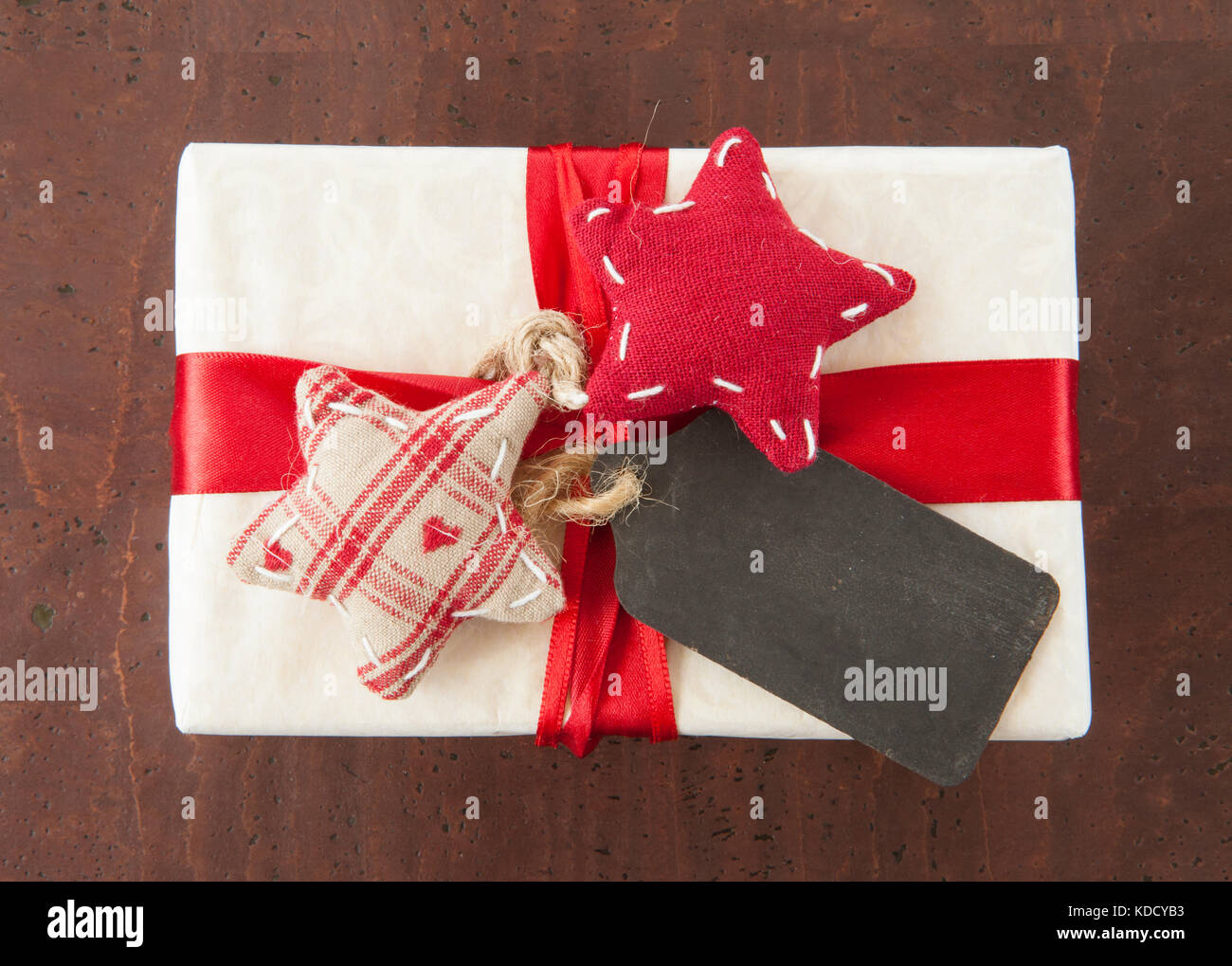 Little wrapped present with red ribbons and a gift tag for christmas ...