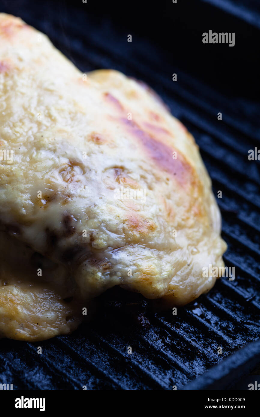 Chicken topped with melted cheese on a cast iron skillet Stock Photo ...