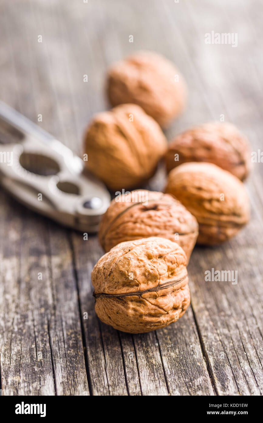 Tasty dried walnuts and nutcracker on old wooden table Stock Photo - Alamy